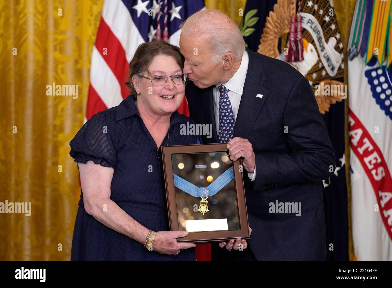 President Joe Biden kisses Debra Nelson McKnight after presenting the ...