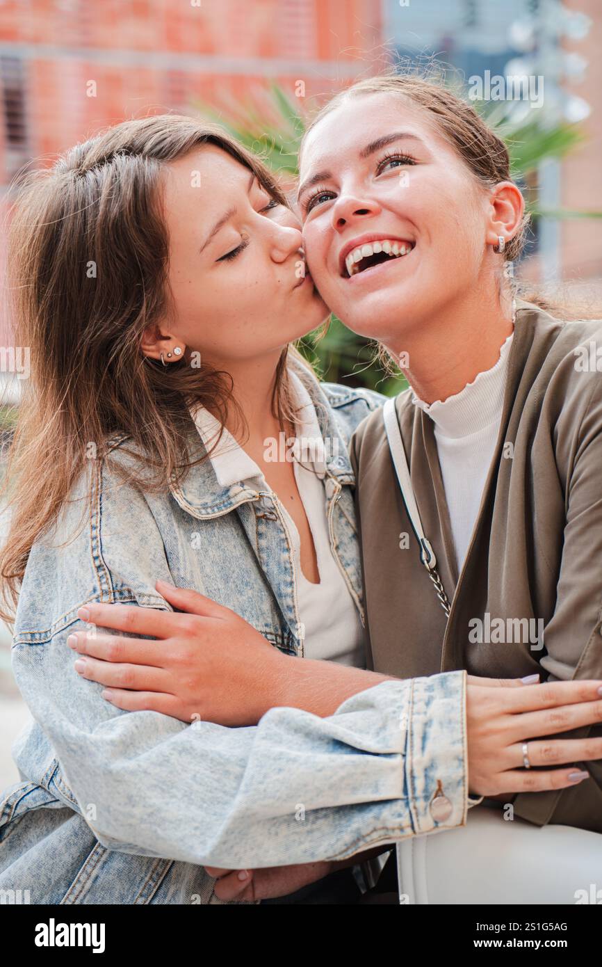 Vertical. Joyful moment of affection between two female friends as one ...