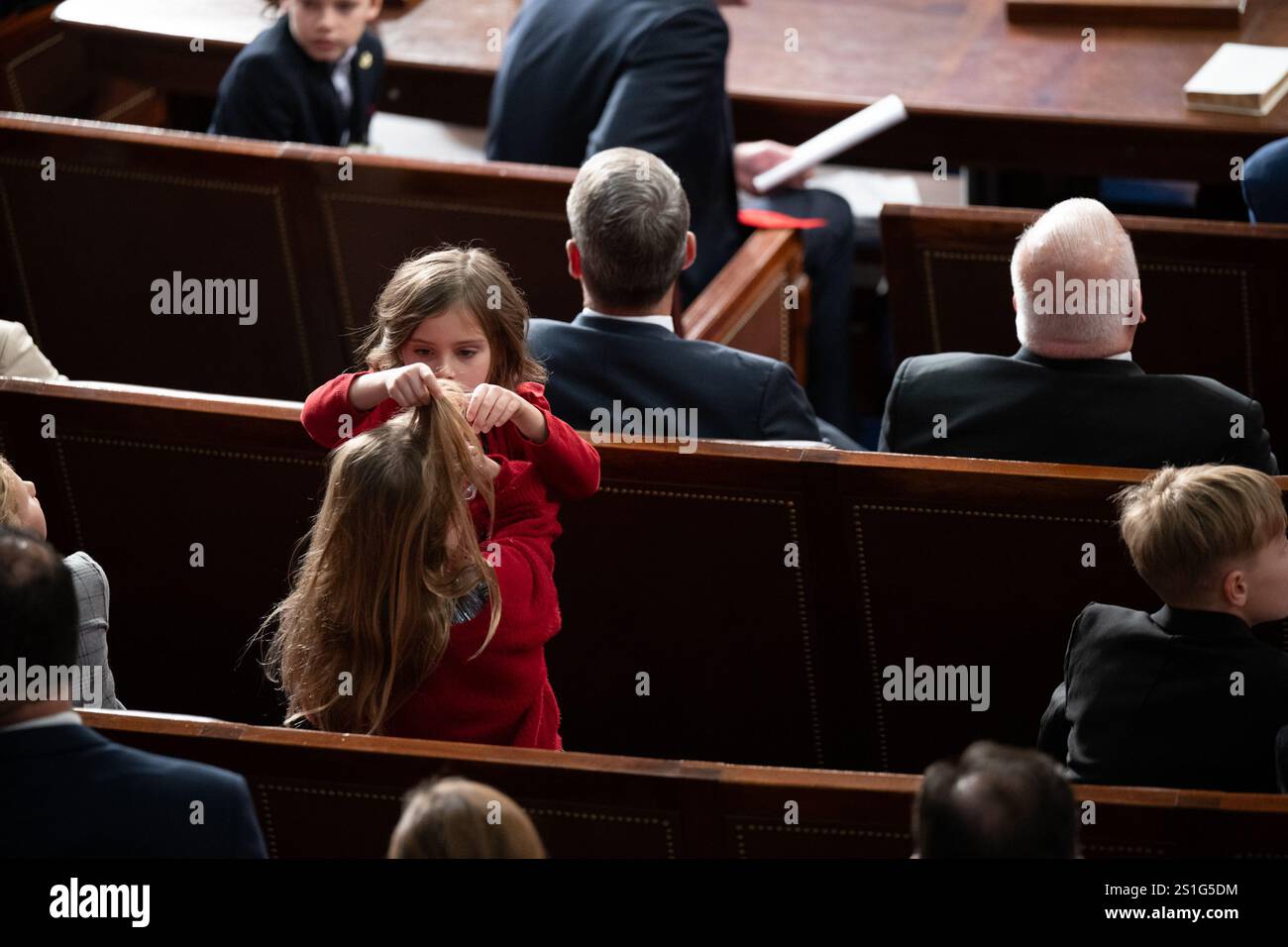Washington, USA. 03rd Jan, 2025. A girl plays with another girl's hair ...