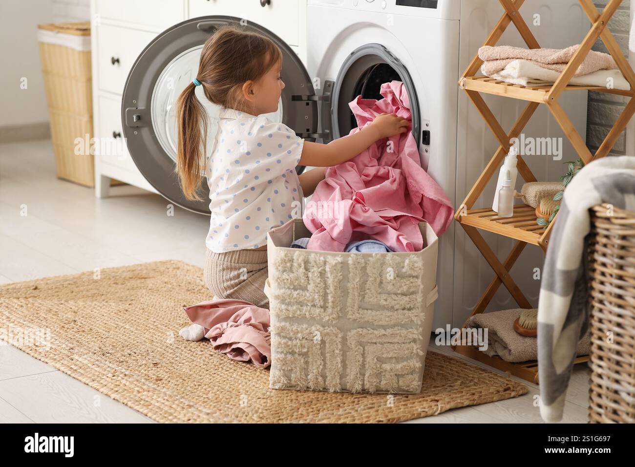 Little girl doing laundry at home Stock Photo - Alamy