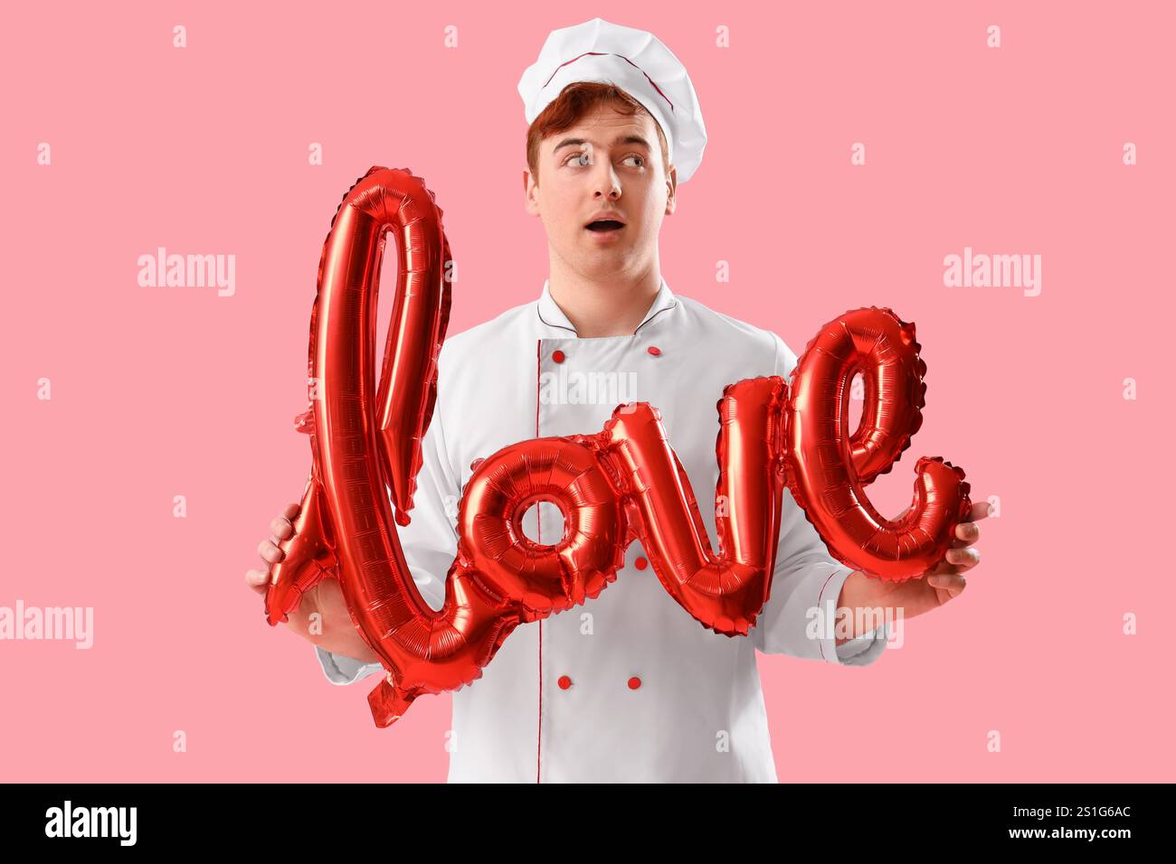 Male chef with word LOVE made of balloons on pink background. Valentine ...