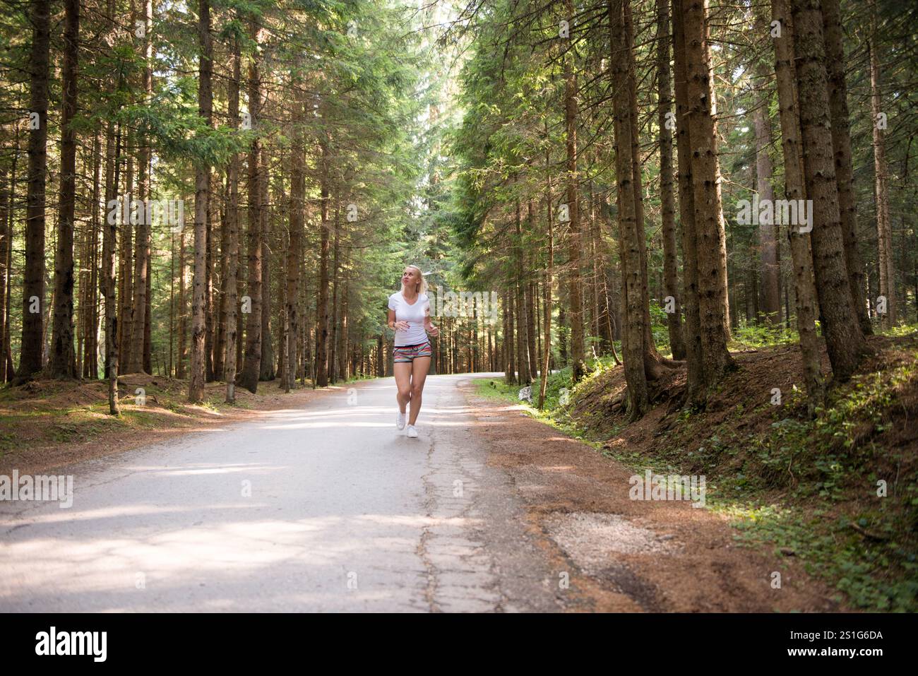 Jogging Along A Forest Road With Wide Open Spaces And Greenery Stock ...
