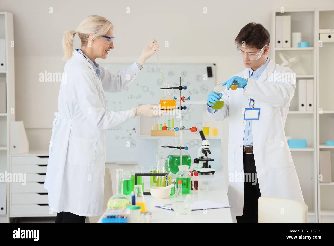 Chemists conducting experiment in laboratory Stock Photo - Alamy
