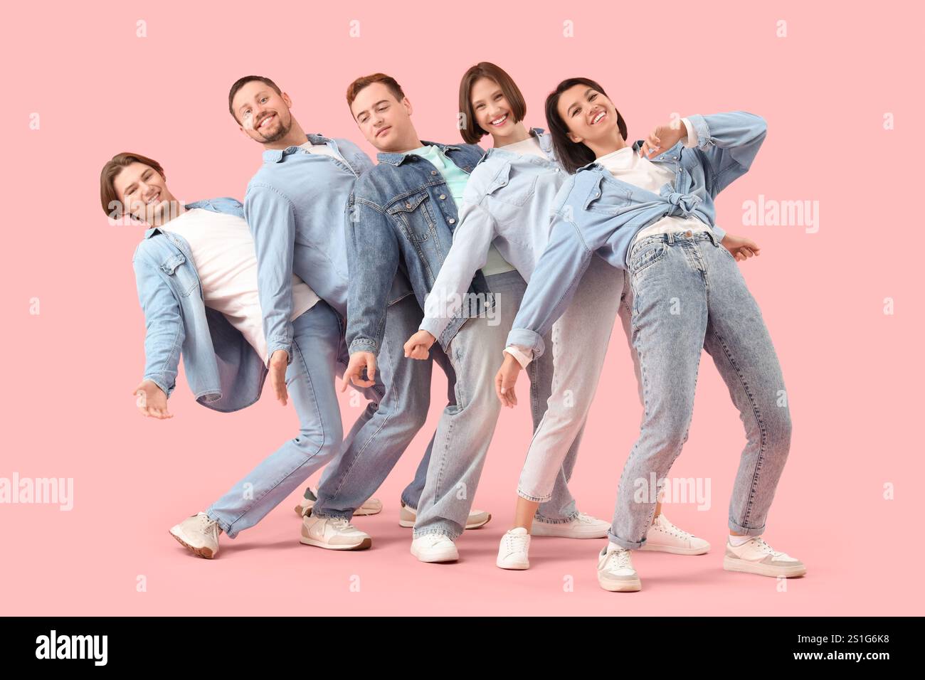 Group of young people in denim clothes dancing on pink background Stock ...