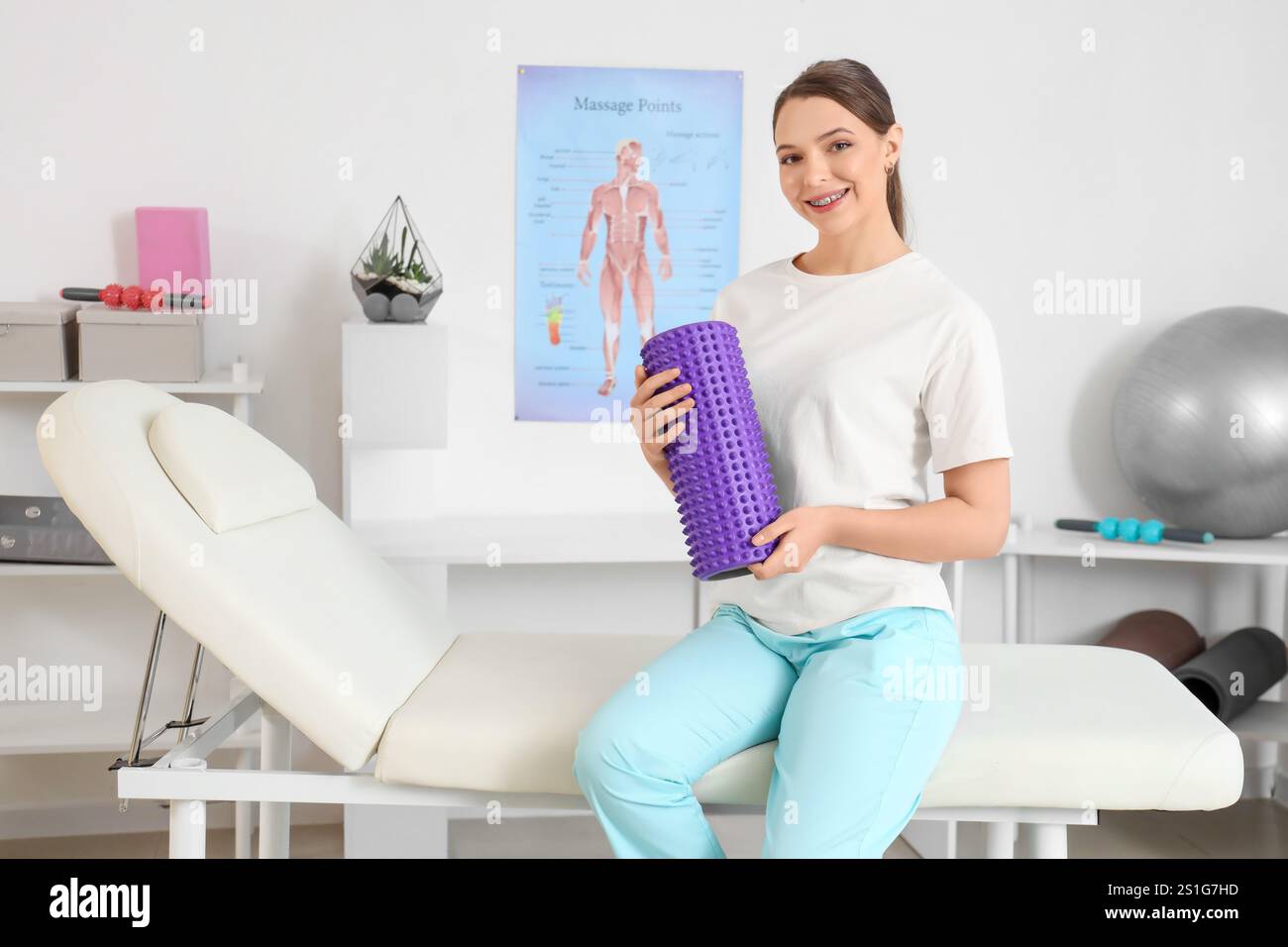 Female physiotherapist with foam roller sitting on couch in ...