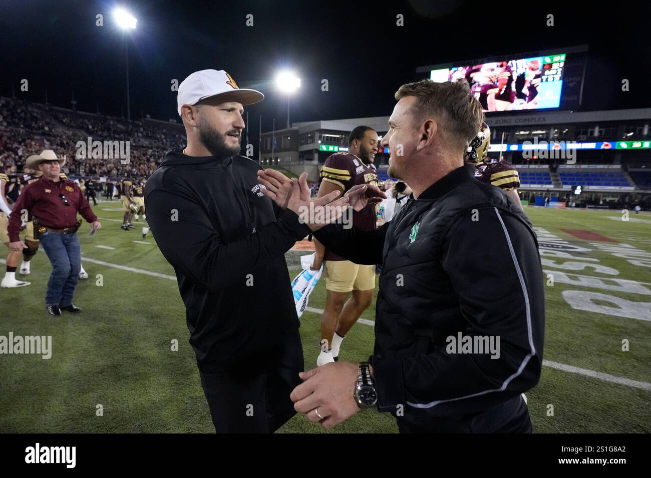 Texas State head coach GJ Kinne, left, shakes hands with North Texas ...