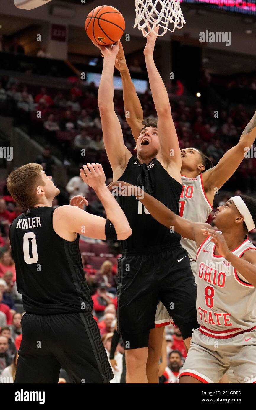 Michigan State center Szymon Zapala, center front, shoots in front of Ohio State guard Micah ...