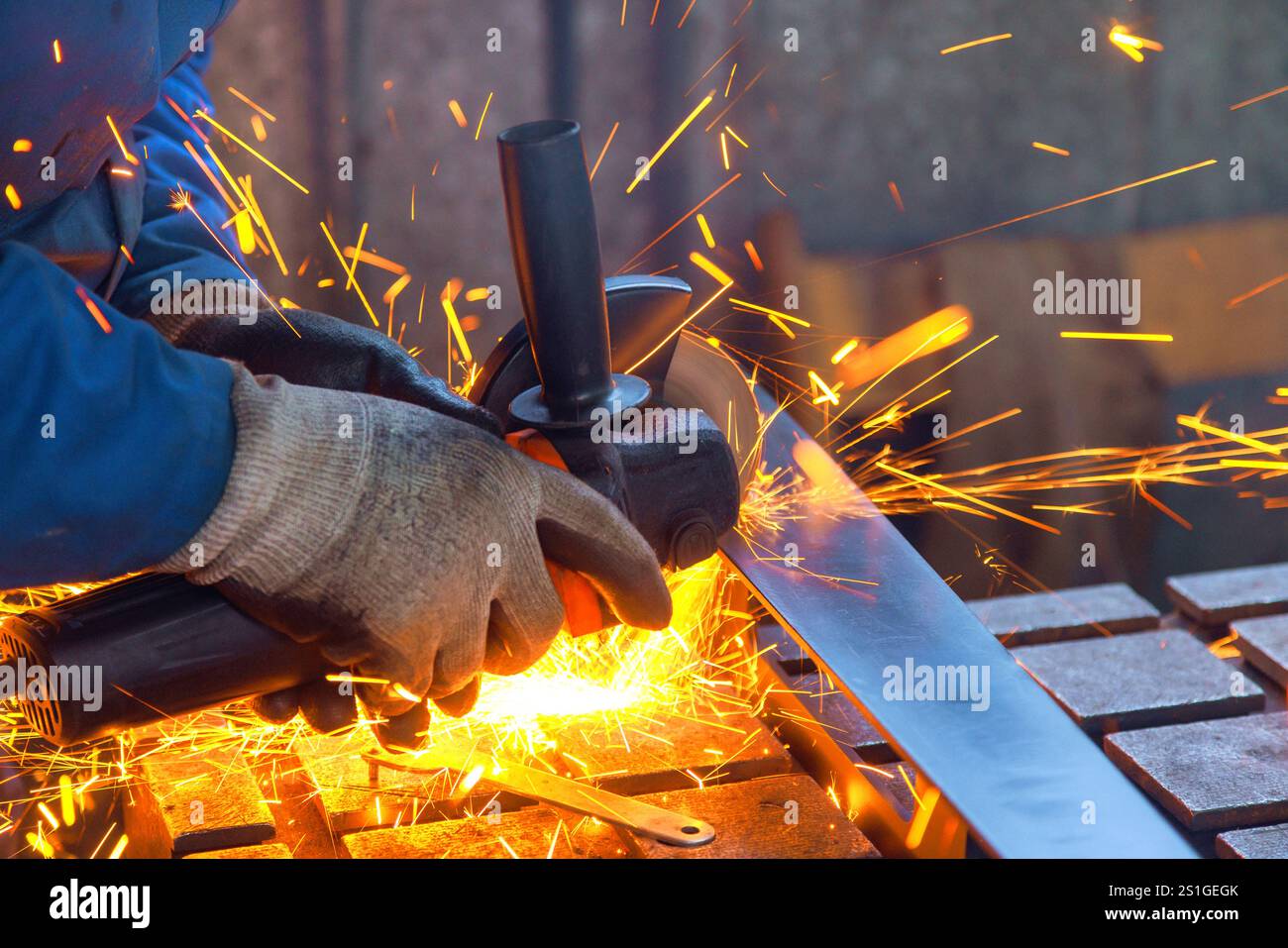 Worker skillfully operates grinding tool, creating bright sparks while ...
