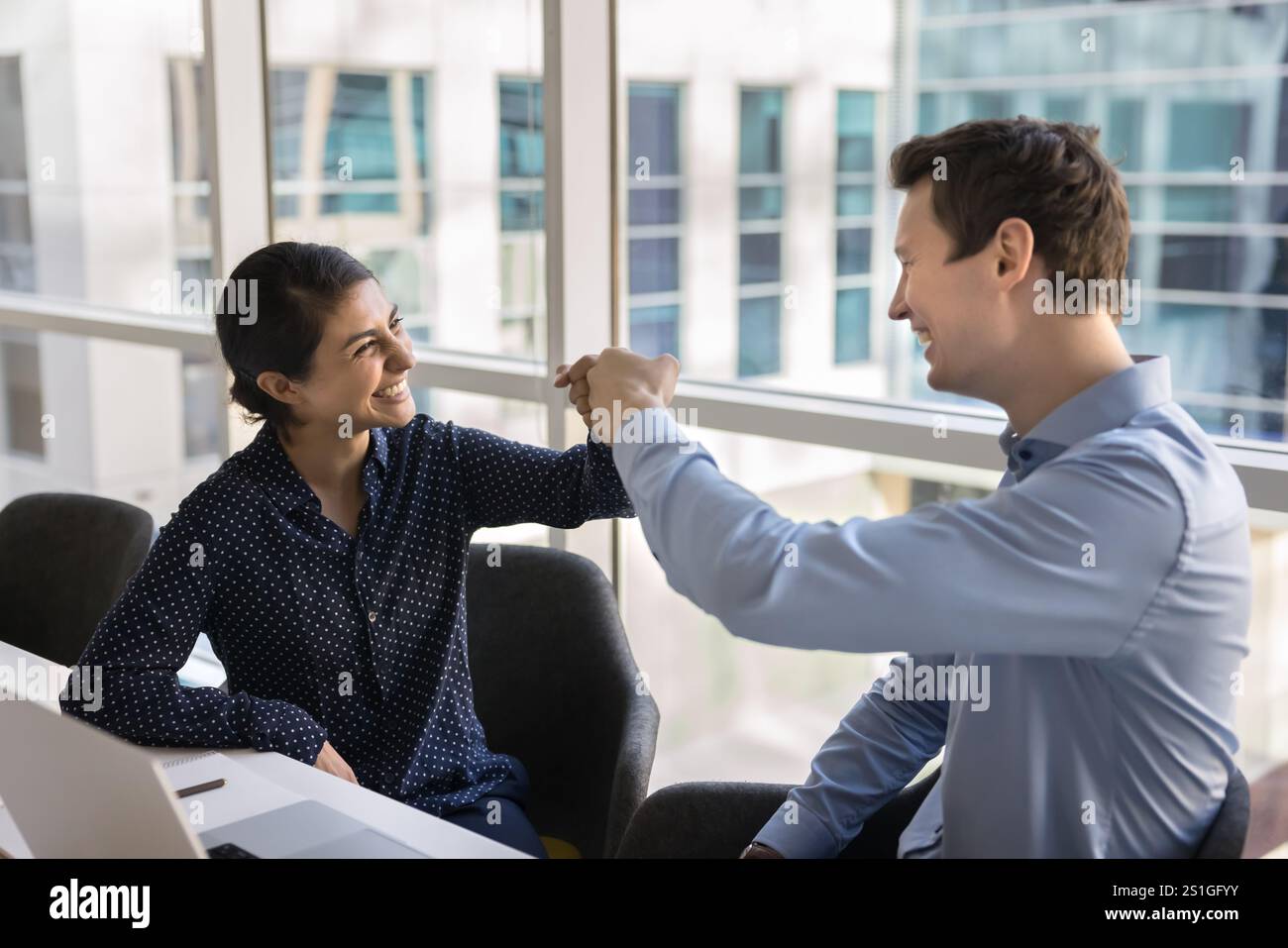 Cheerful office coworkers making fist bump friends gesture Stock Photo ...