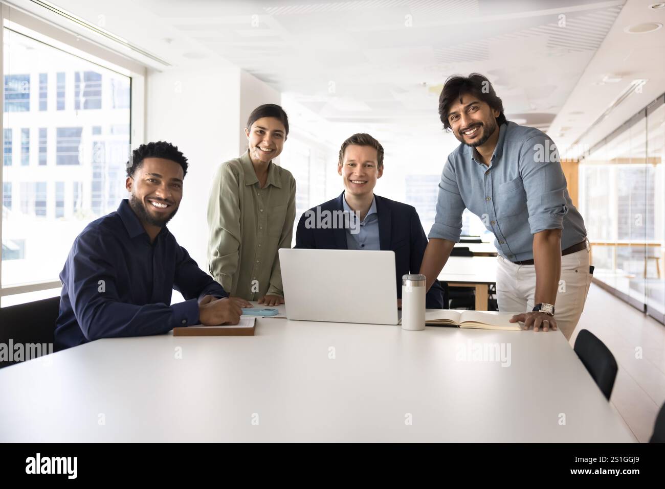 Four happy diverse co-workers standing together at workplace Stock ...