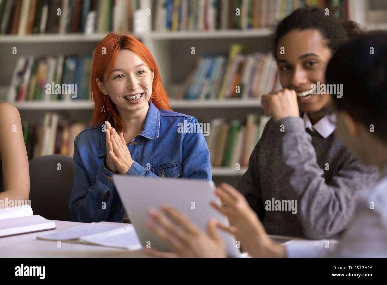 Excited diverse adolescent students laugh applaud to mate in library Stock Photo - Alamy