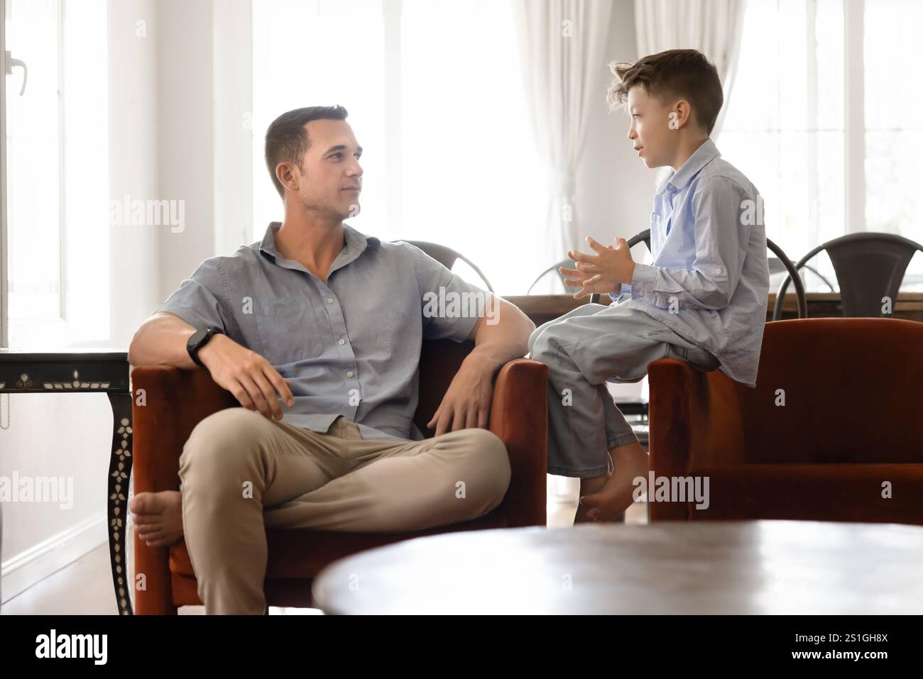 Positive handsome dad talking to son kid at home Stock Photo - Alamy