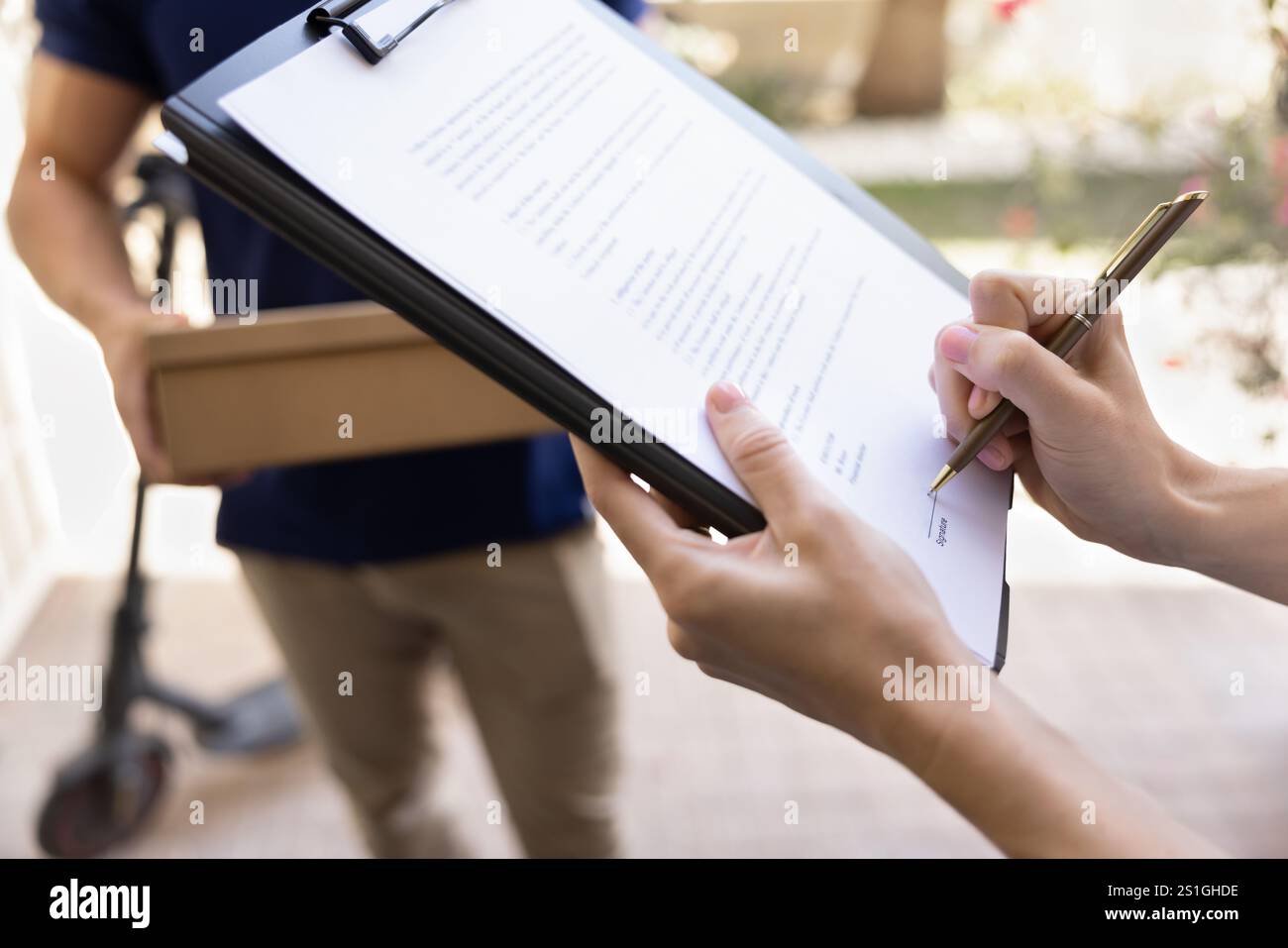 Female delivery service client signing paper confirmation of receiving ...