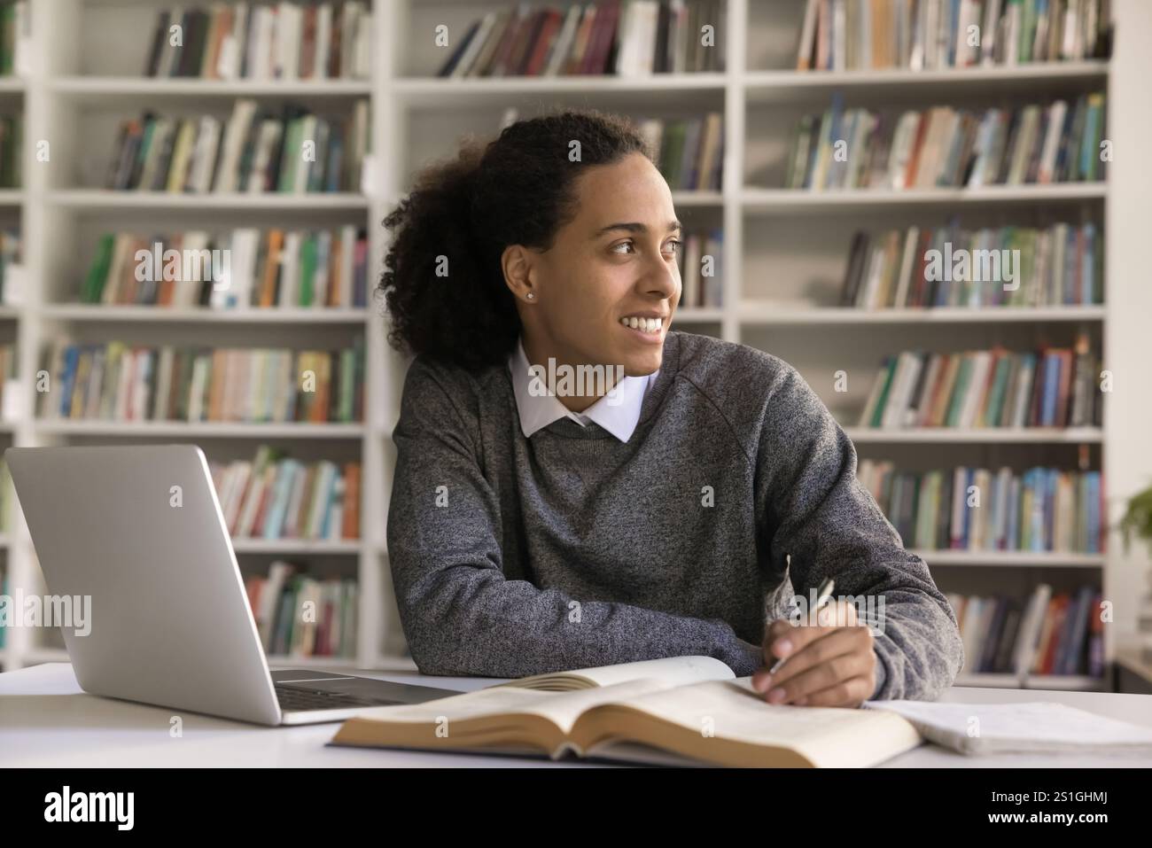Teenage male learning at library look aside distracted from books Stock ...