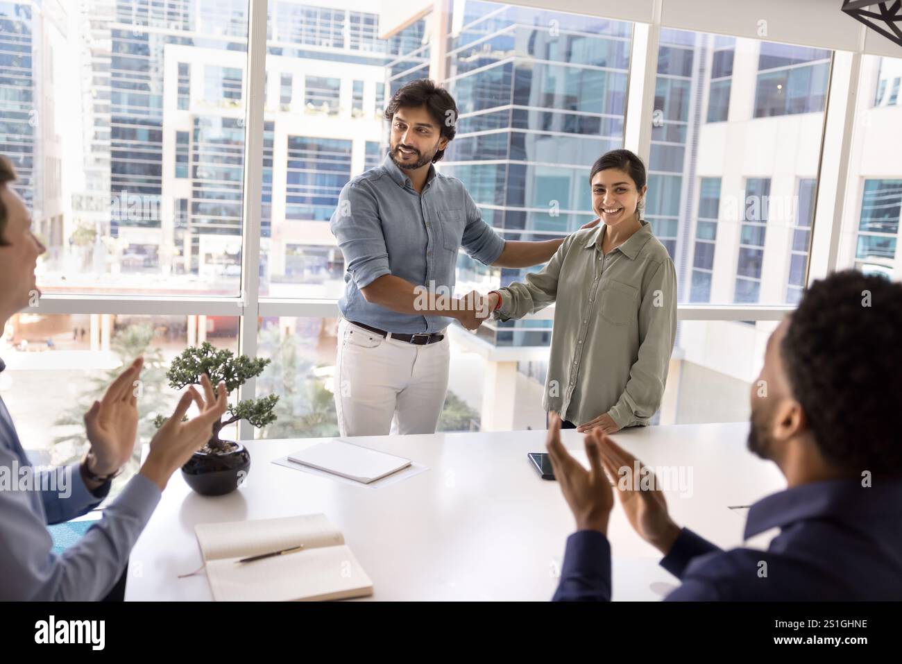 Positive male Indian boss shaking hands with happy employee Stock Photo ...