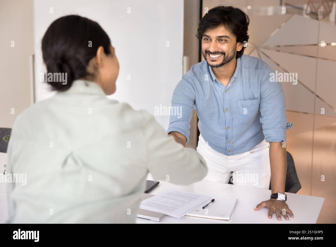Happy Indian businessman shaking hands with female business partner ...