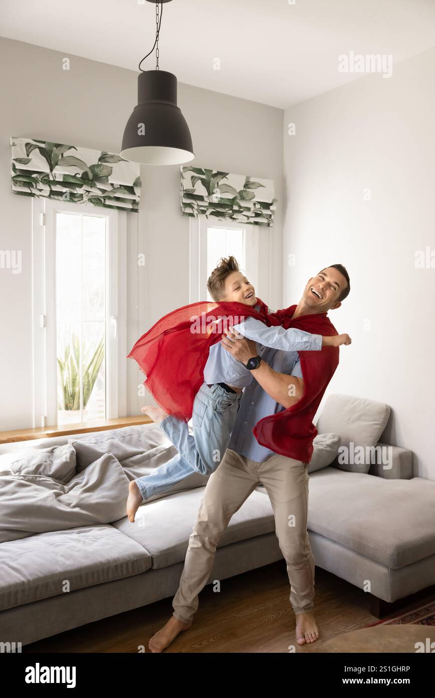 Cheerful carefree dad lifting kid, holding child in arms Stock Photo ...