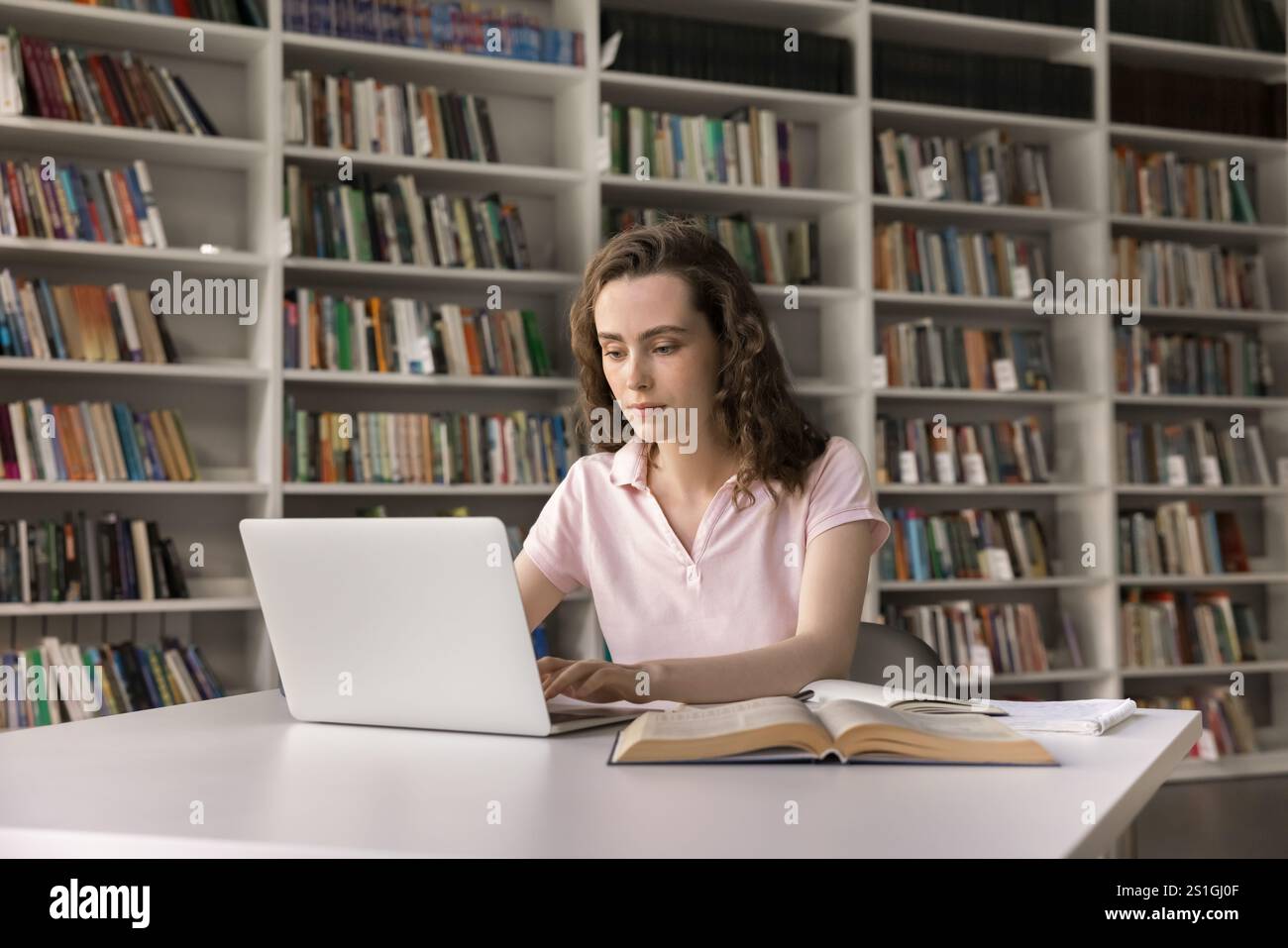 Millennial woman student learning on distance at library using pc Stock ...