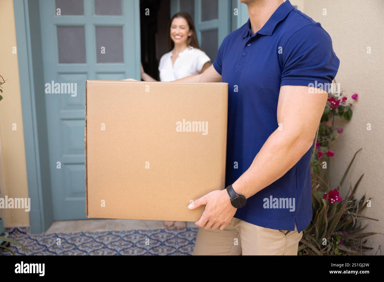 Strong male loader man carrying large package from female customer ...