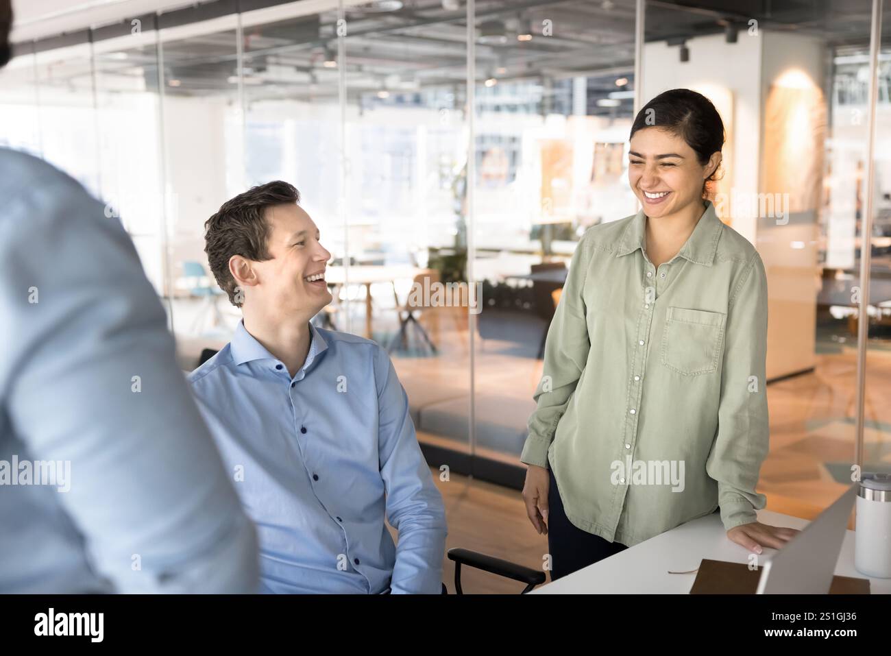 Happy young Indian business professional woman talking to male ...