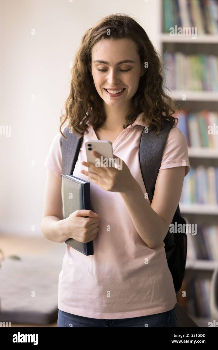 Confident teenage girl student using app on smartphone at library Stock ...