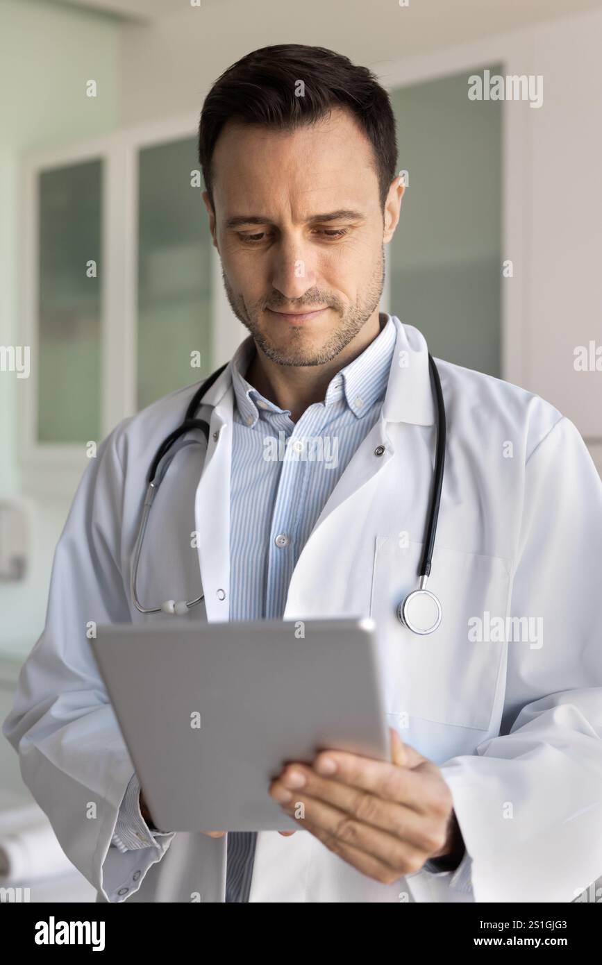 Focused doctor man checking patients records, histories, electronic ...