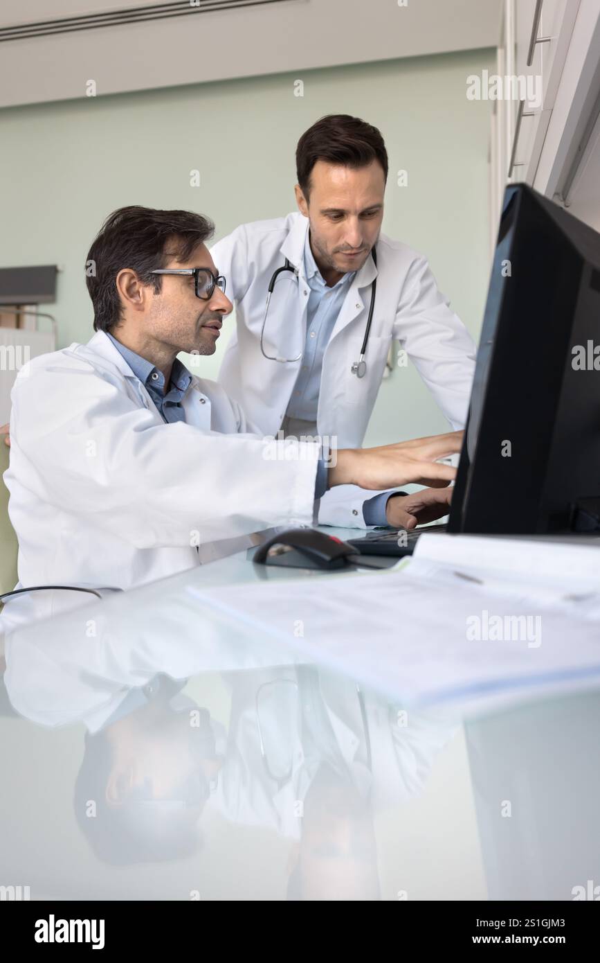 Team of two male doctors reviewing medical case at computer Stock Photo ...