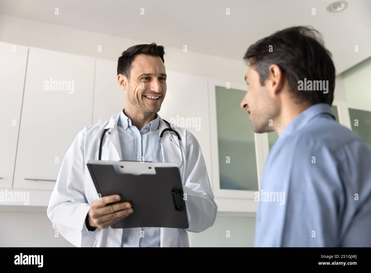 Happy doctor sharing good news with patient, holding medical report ...