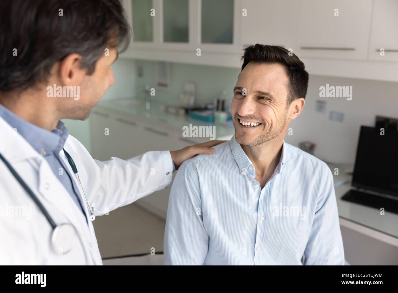Cheerful patient man getting supportive shoulder touch gesture from ...