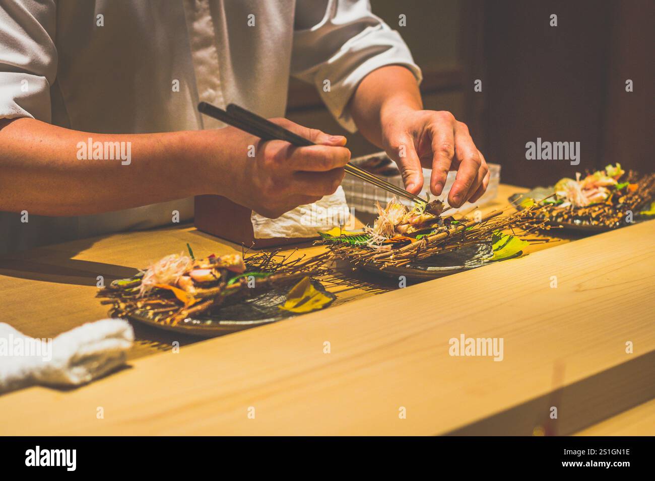 a japanese chef's hands preparing dishes in a kaiseki omakase ...
