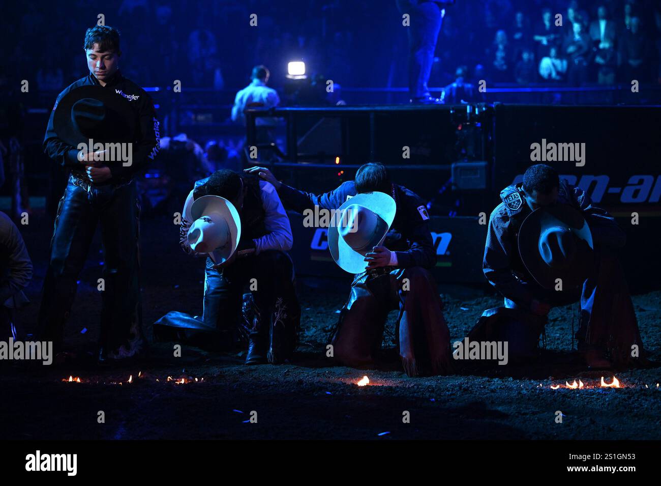 Professional bull riders take a moment of prayer before the start of ...