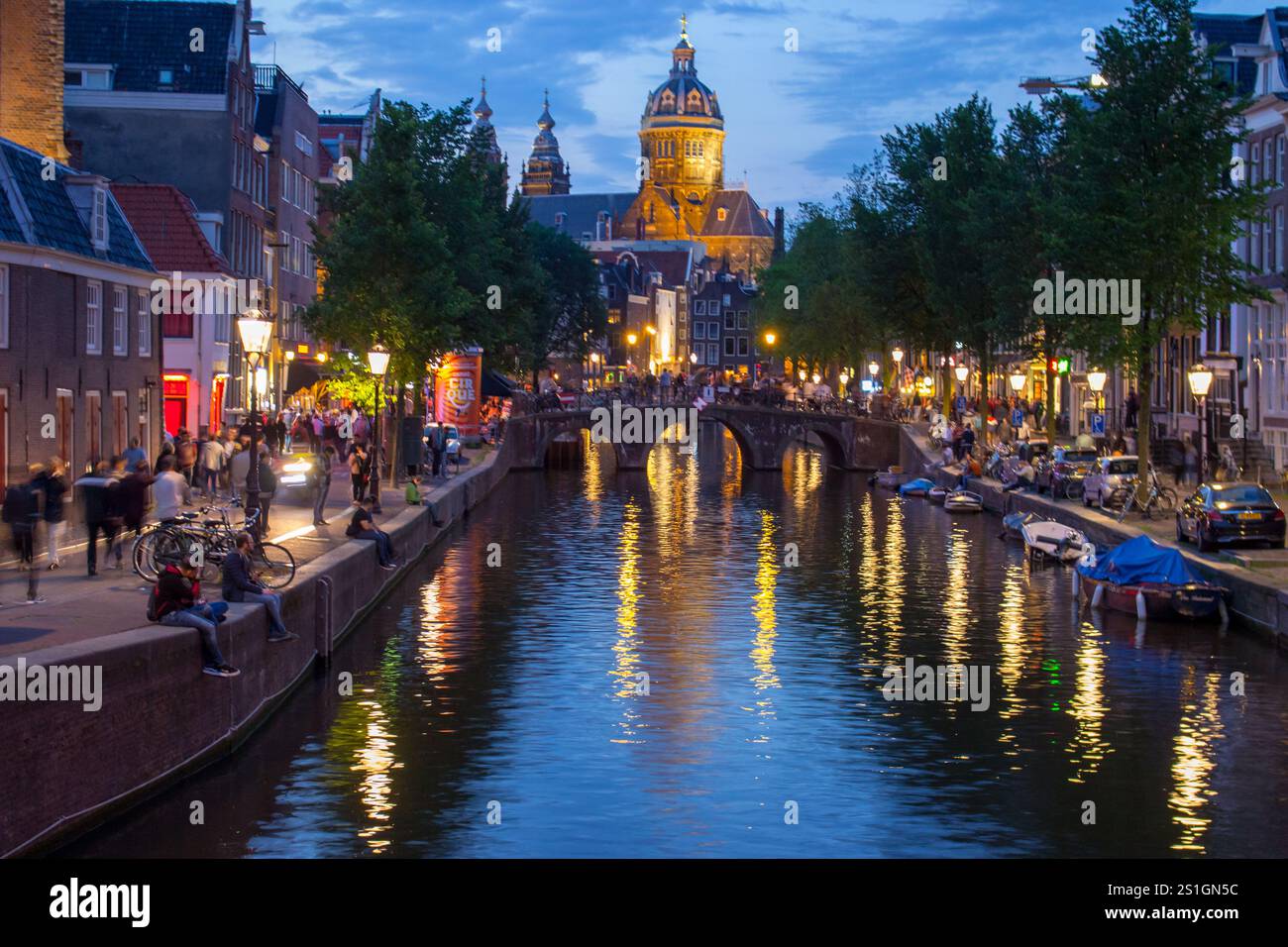 Canal with bridge, cathedral and boats in evening Amsterdam ...