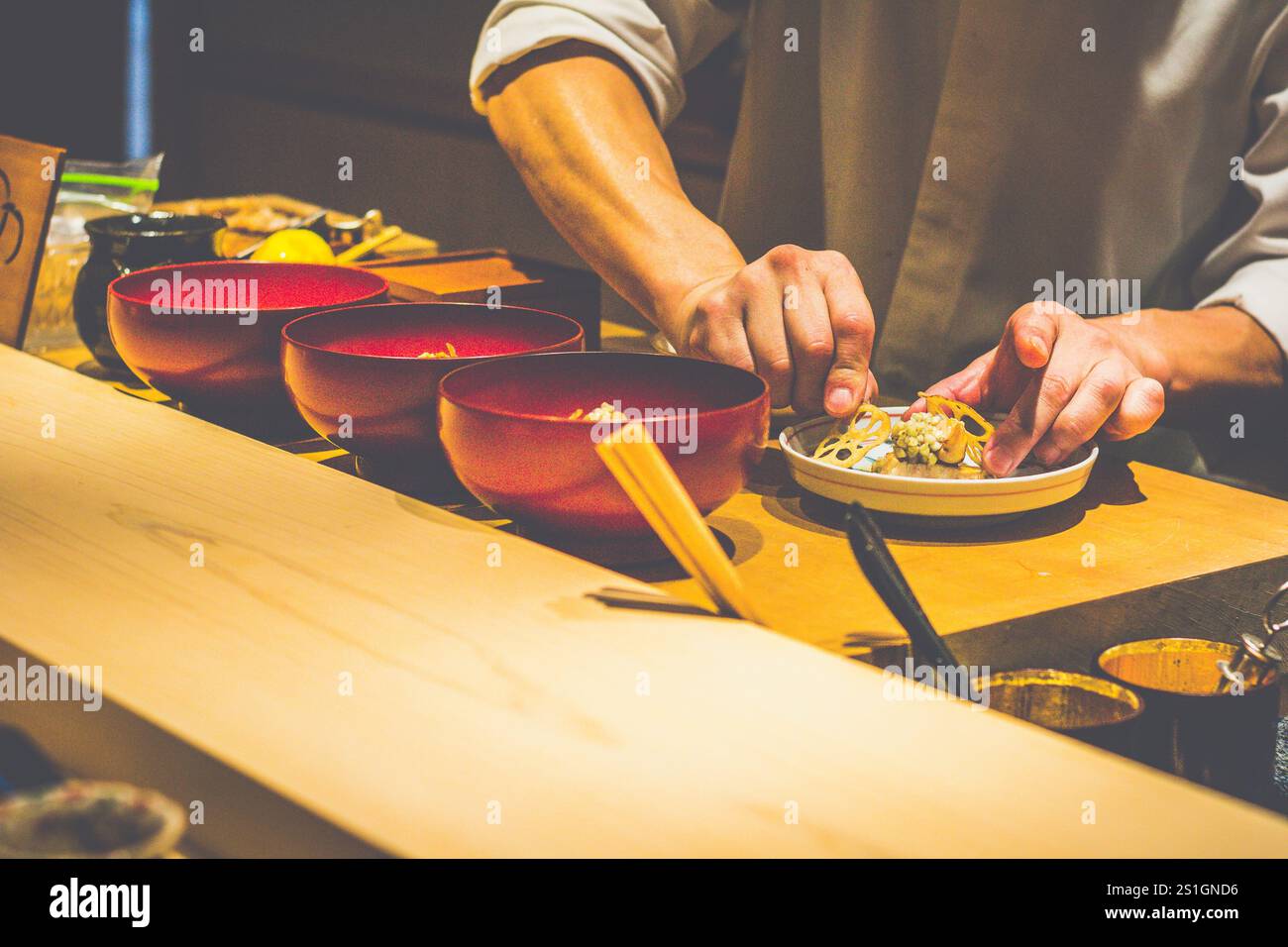 a japanese chef's hands preparing dishes in a kaiseki omakase ...