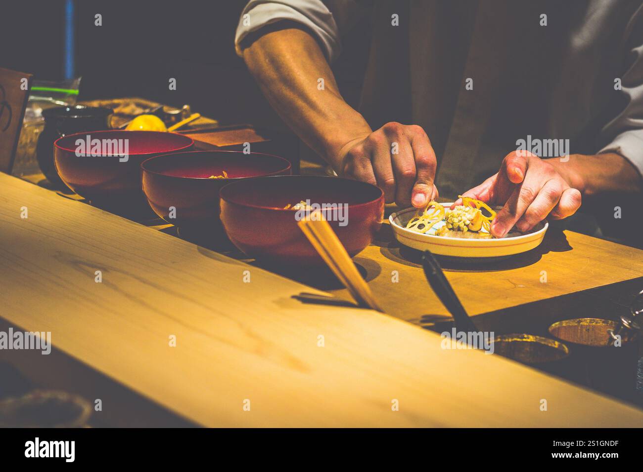 a japanese chef's hands preparing dishes in a kaiseki omakase ...