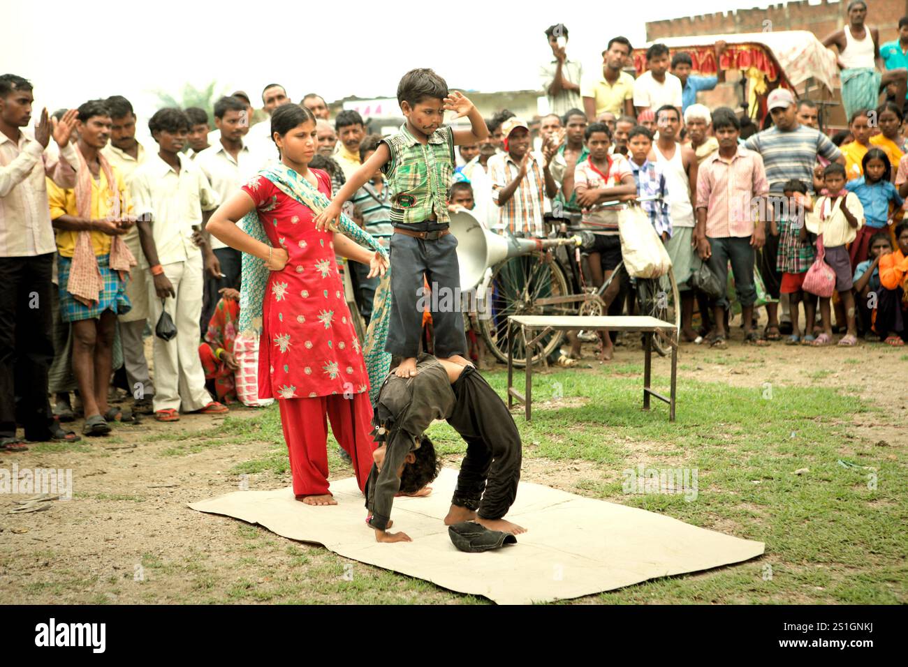 Children performing a gymnastic stunt in front of tens of spectators on ...