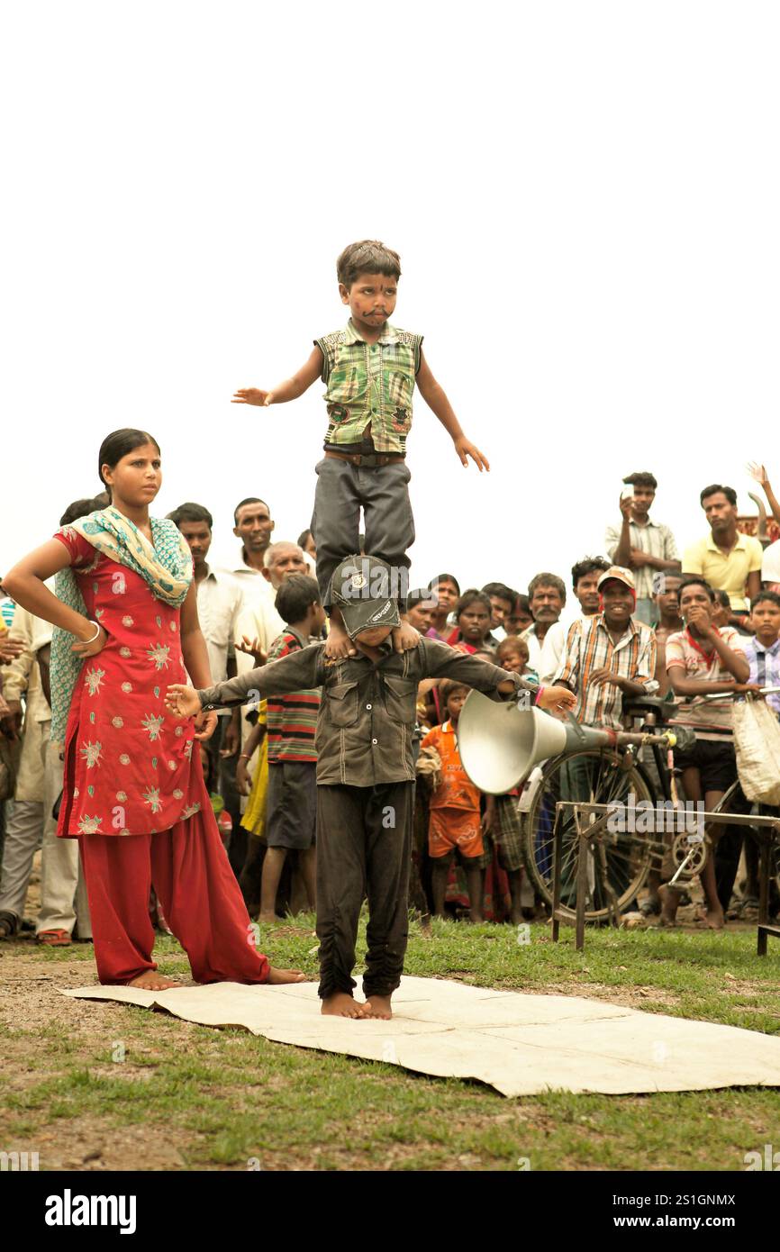 Children performing a gymnastic stunt in front of tens of spectators on ...