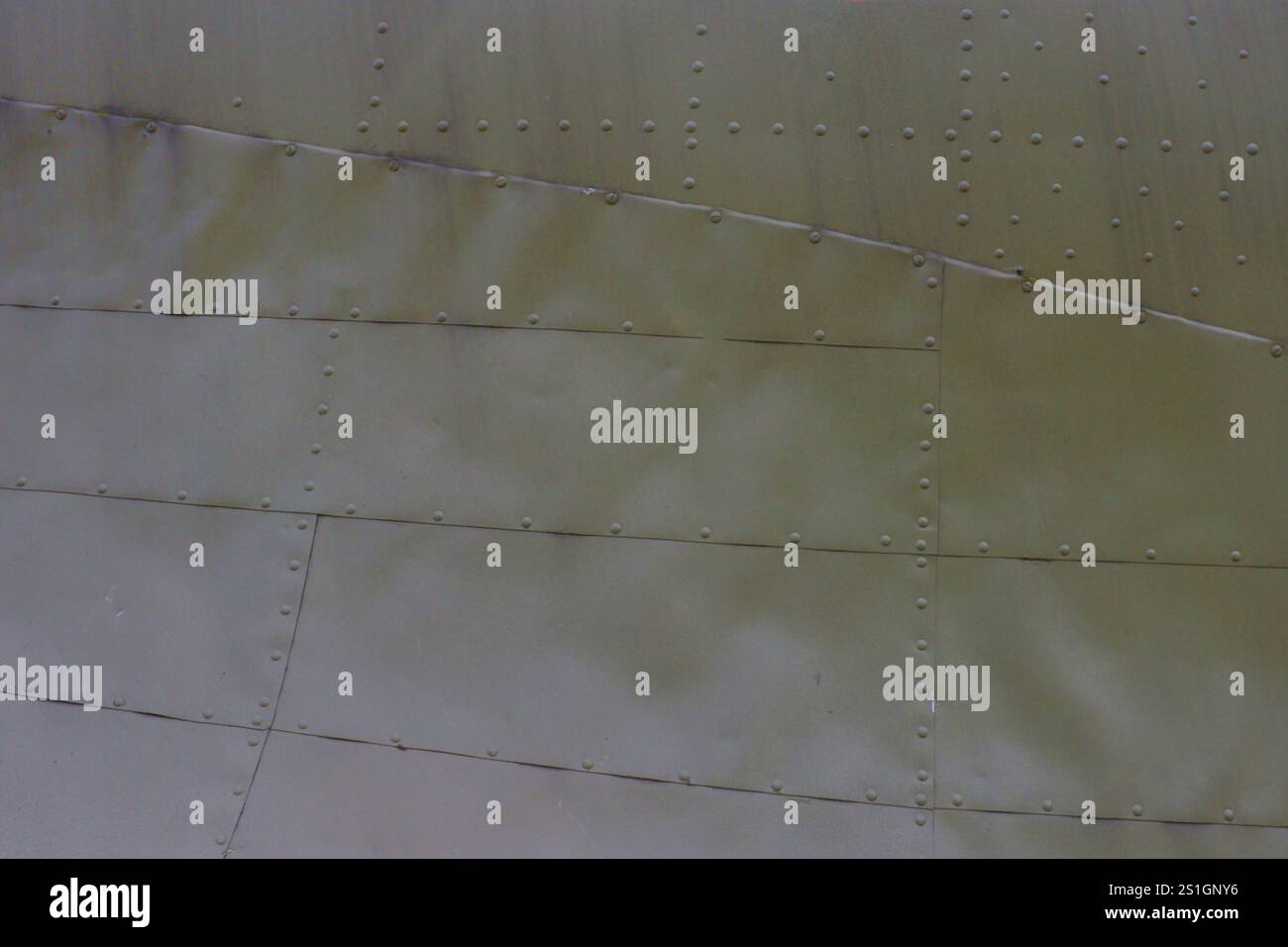 Airplane fuselage cladding surface is green. Textured metal and bolts ...