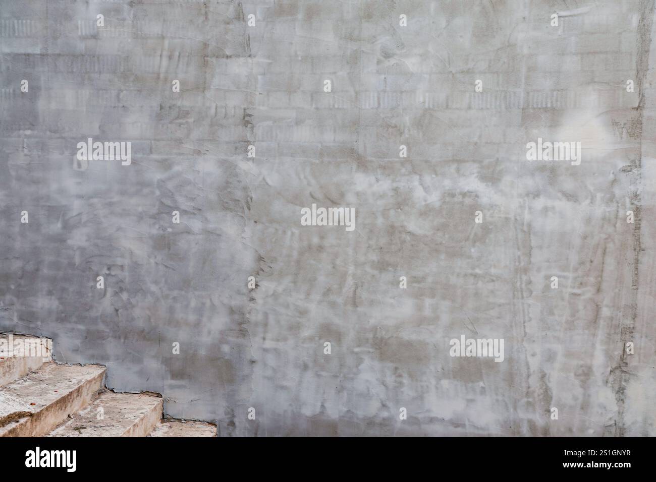 A wall with grey plaster and a fragment of a staircase Stock Photo - Alamy