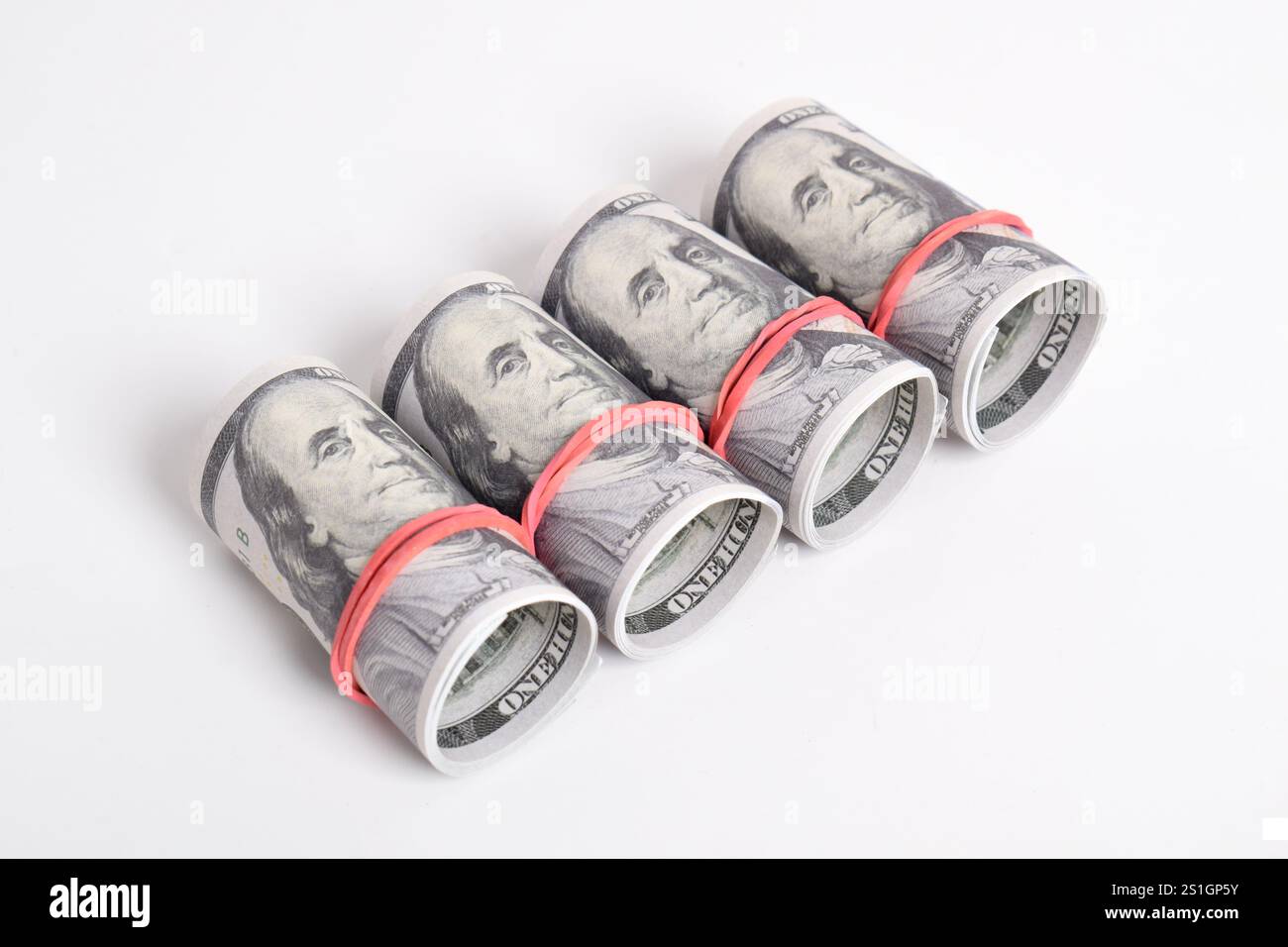 A row of rolled hundred dollar bills with rubber bands isolated on ...