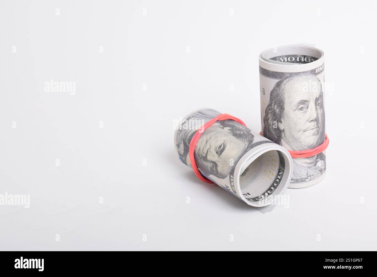 Dollar roll wrapped with red rubber. 100 dollar bills on a roll ...