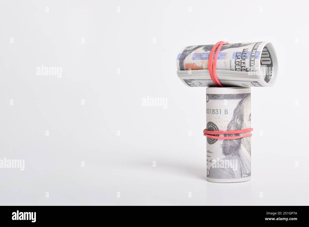 Dollar roll wrapped with red rubber. 100 dollar bills on a roll ...