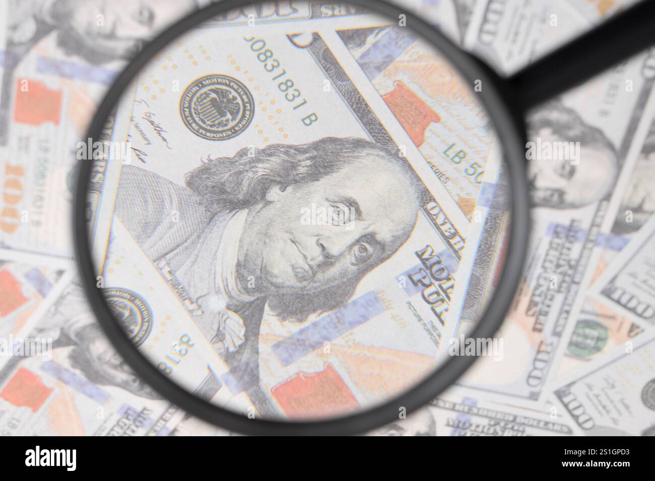 Closeup on magnifier glass with Benjamin Franklin on US dollar banknote ...