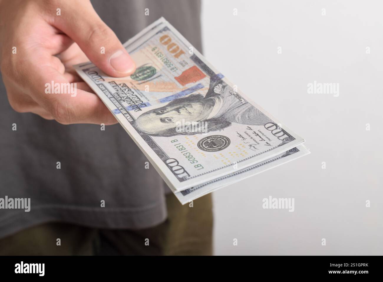 Man hand reaching out dollar bill. Hand holding dollar bill, US $100 ...