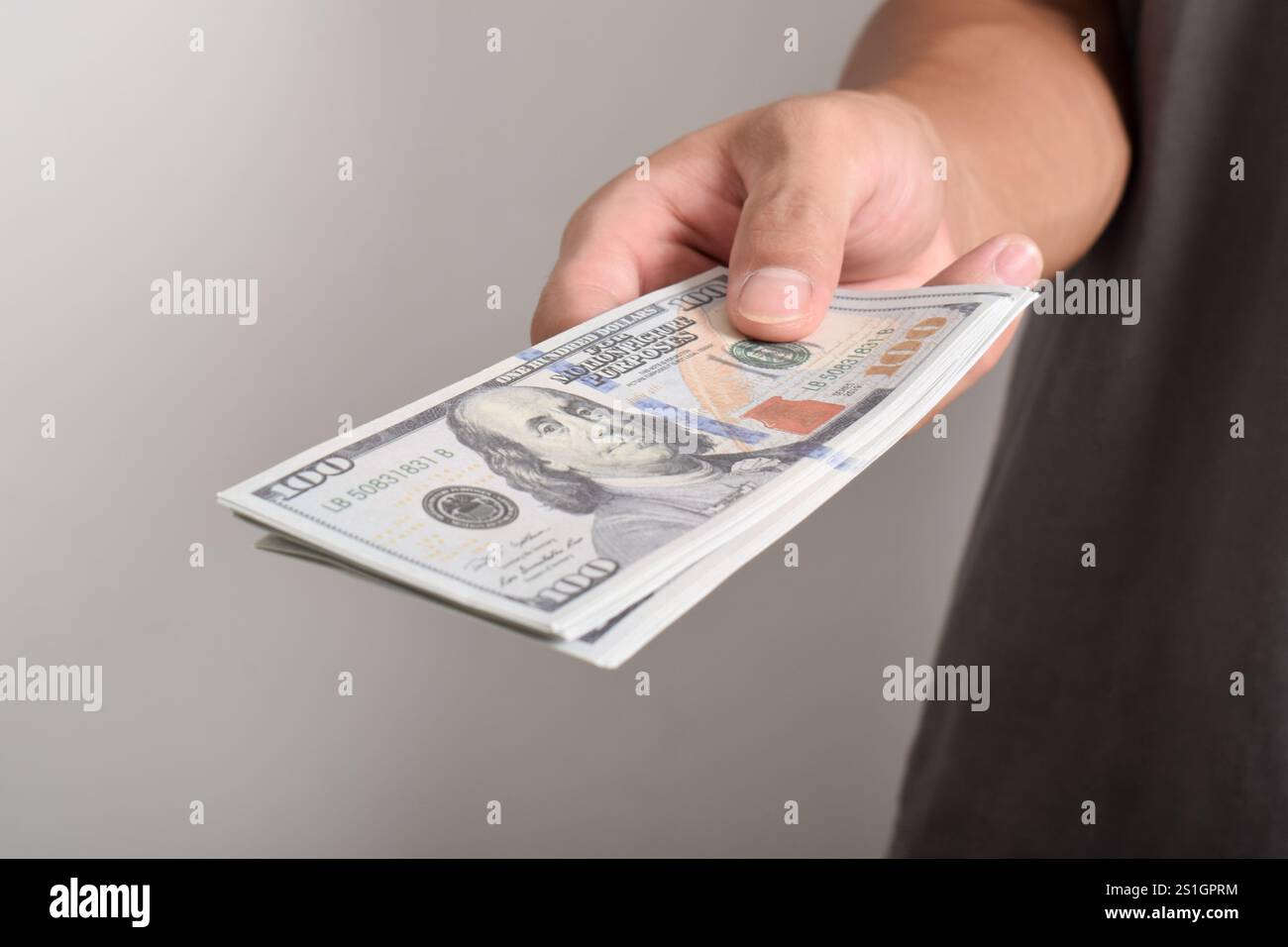 Man hand reaching out dollar bill. Hand holding dollar bill, US $100 ...