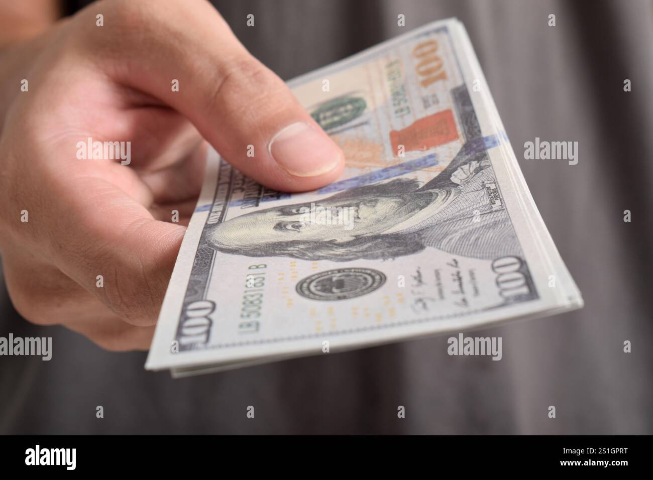 Man hand reaching out dollar bill. Hand holding dollar bill, US $100 ...