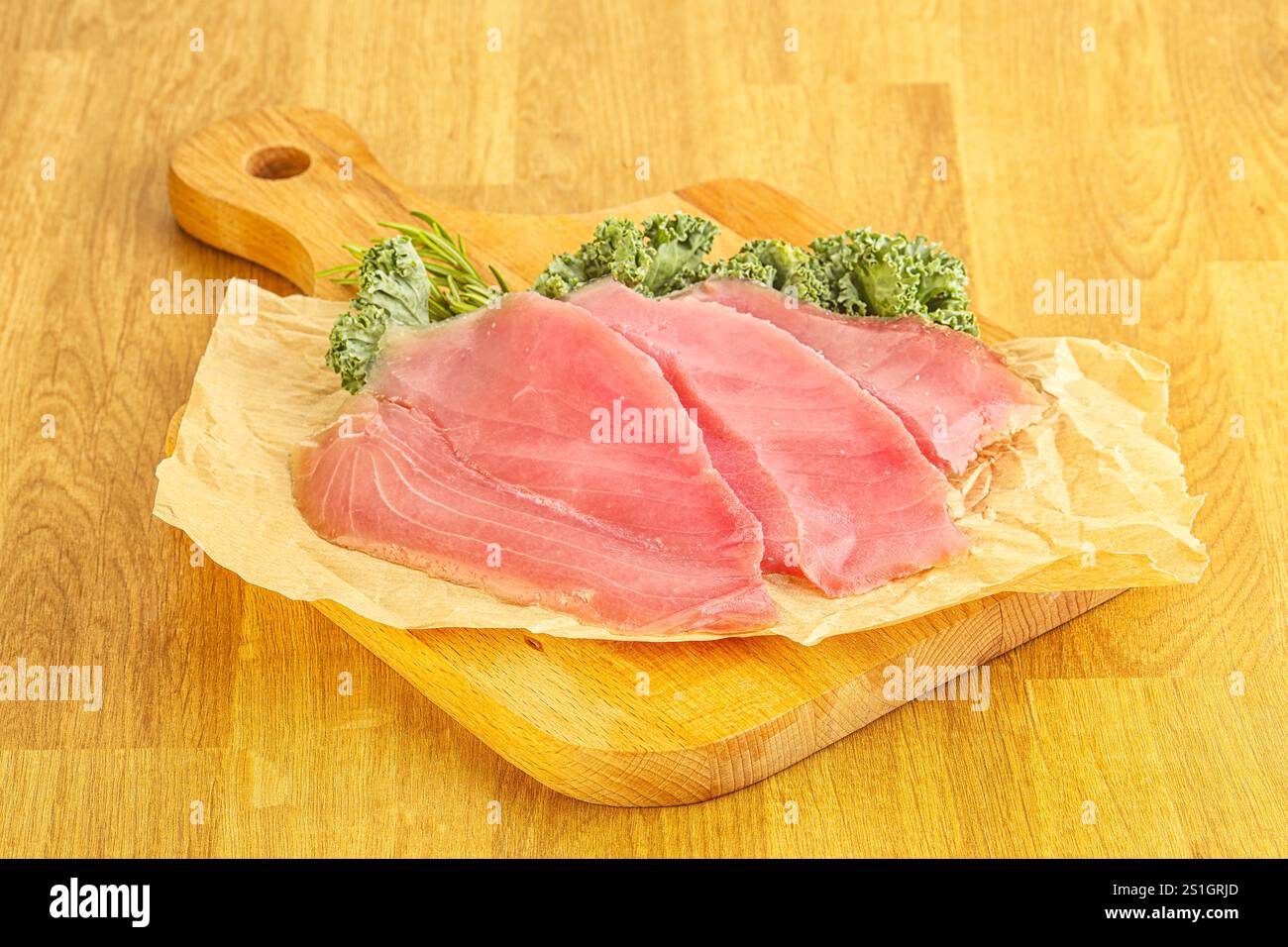 Raw salted tuna slice over board snack Stock Photo - Alamy