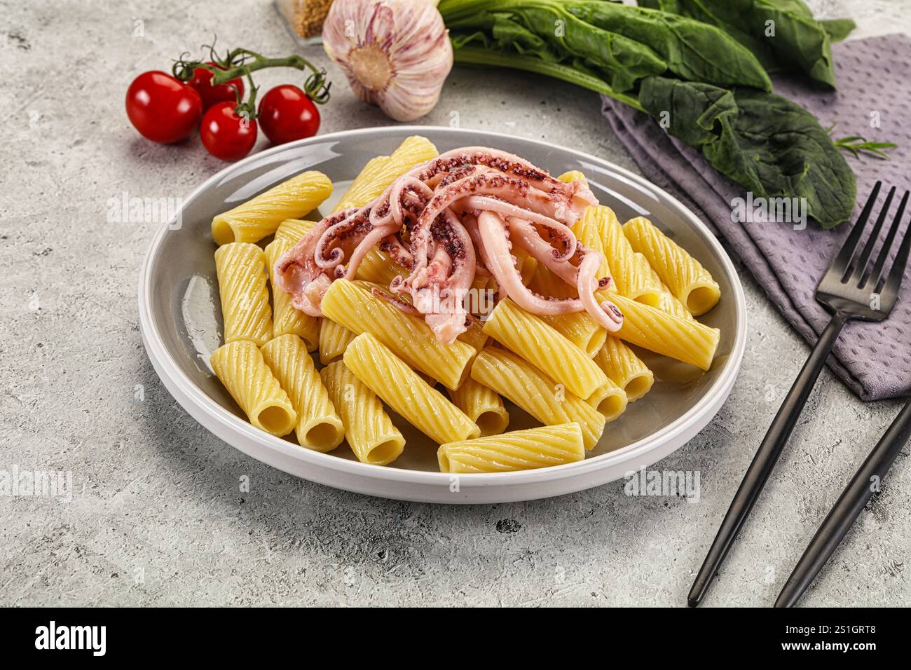 Italian cuisine - pasta tortiglioni with squid tentacles Stock Photo - Alamy