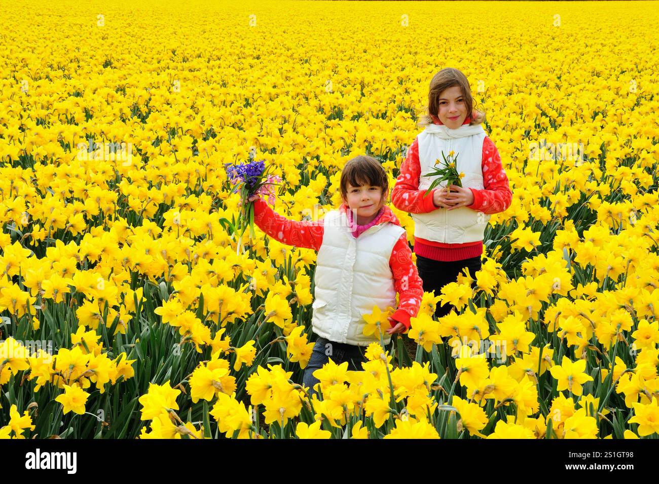 Happy kids with spring flowers on yellow daffodils field, children on ...