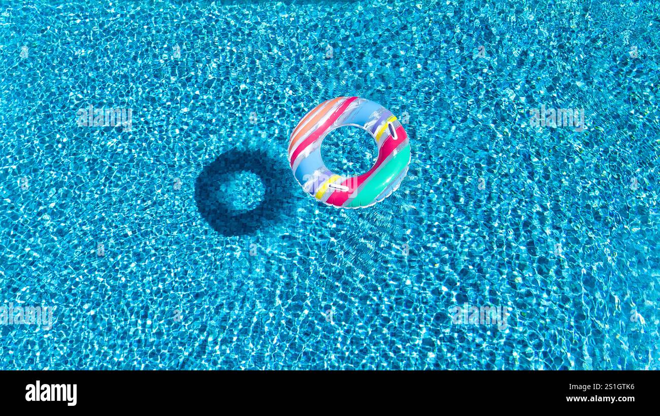 Сolorful inflatable ring donut toy in swimming pool water aerial view ...