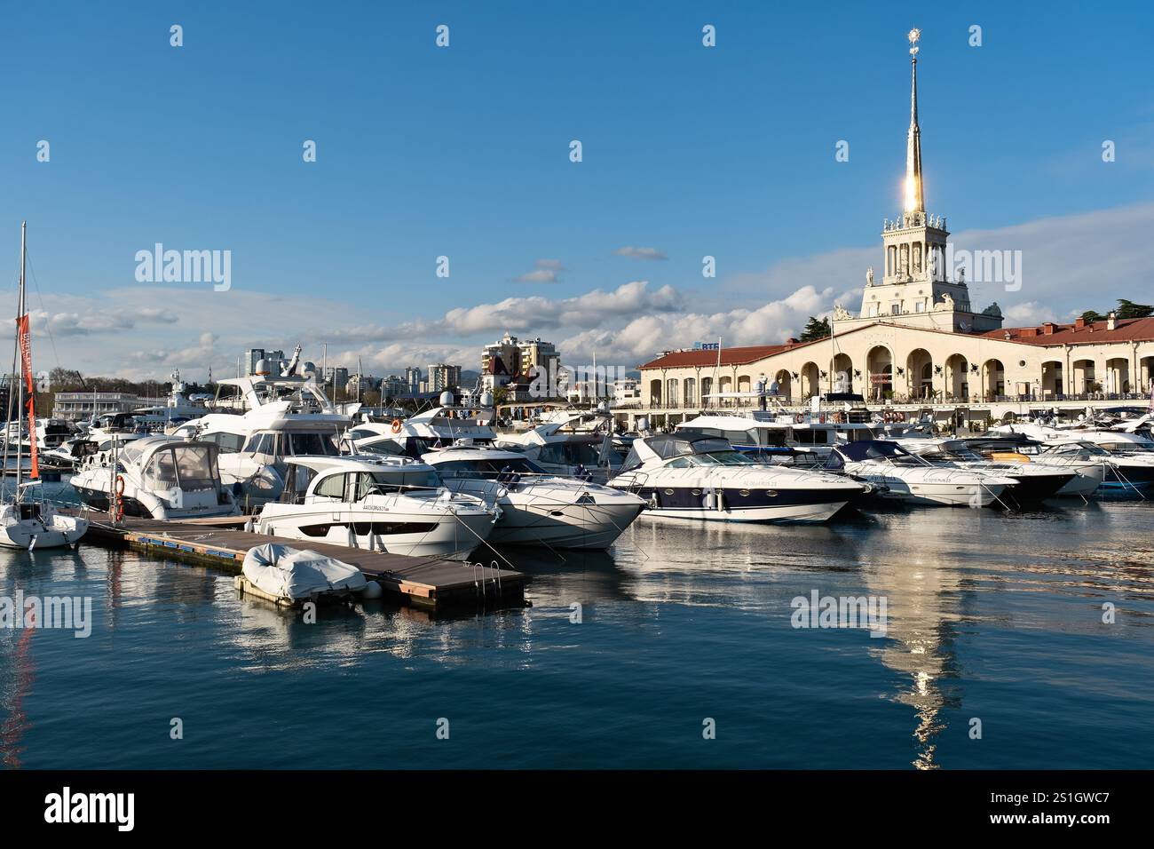 Yachts and boats docked at a marina next to a historic building in a ...